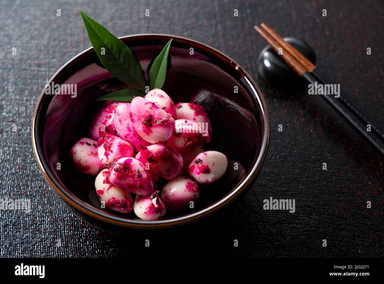 Pickled shiso bonito garlic on a plate placed on a black background ...