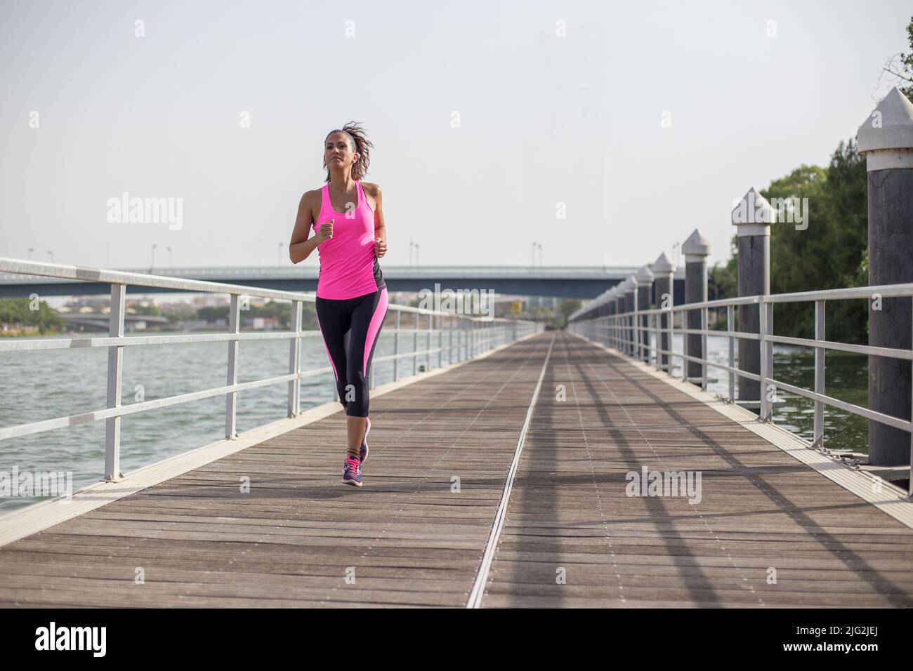 Young woman running by the river in a city Stock Photo - Alamy