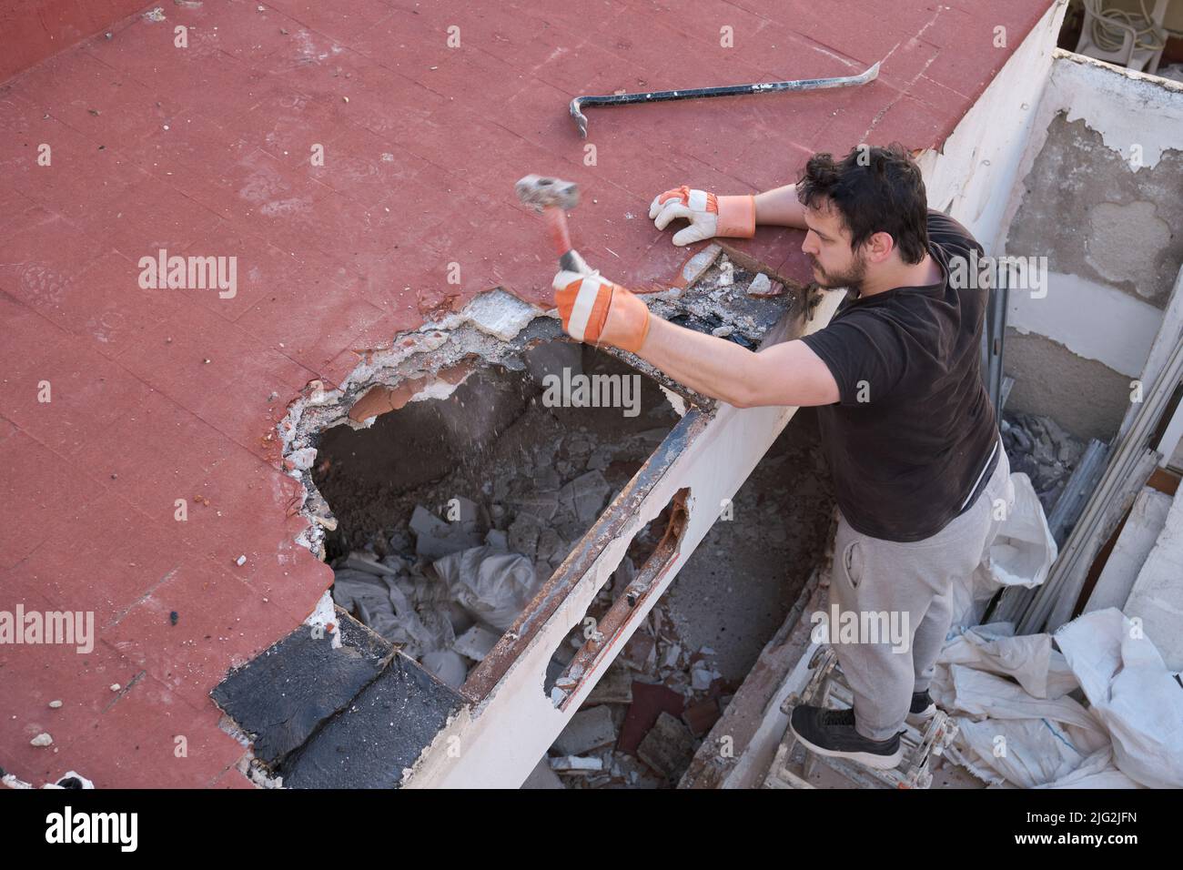 Young man pulling apart the ceiling of a house down Stock Photo - Alamy