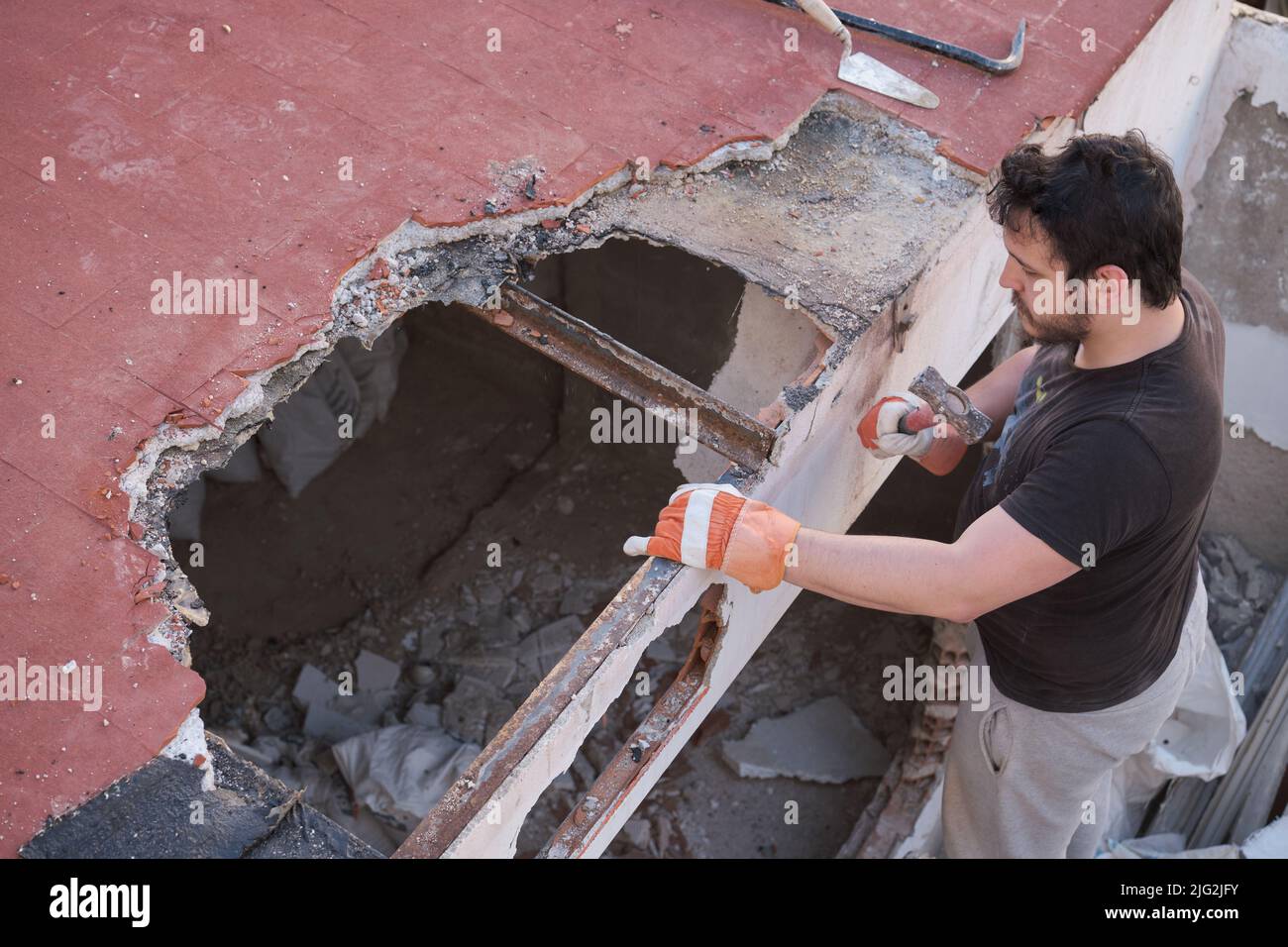 Young man pulling apart the ceiling of a house down Stock Photo - Alamy
