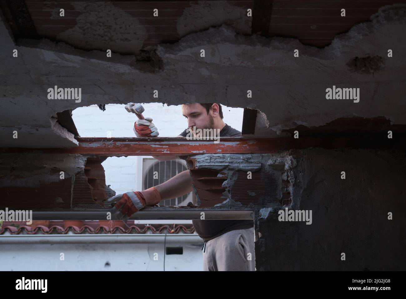 Young man tearing the ceiling of a house down Stock Photo - Alamy