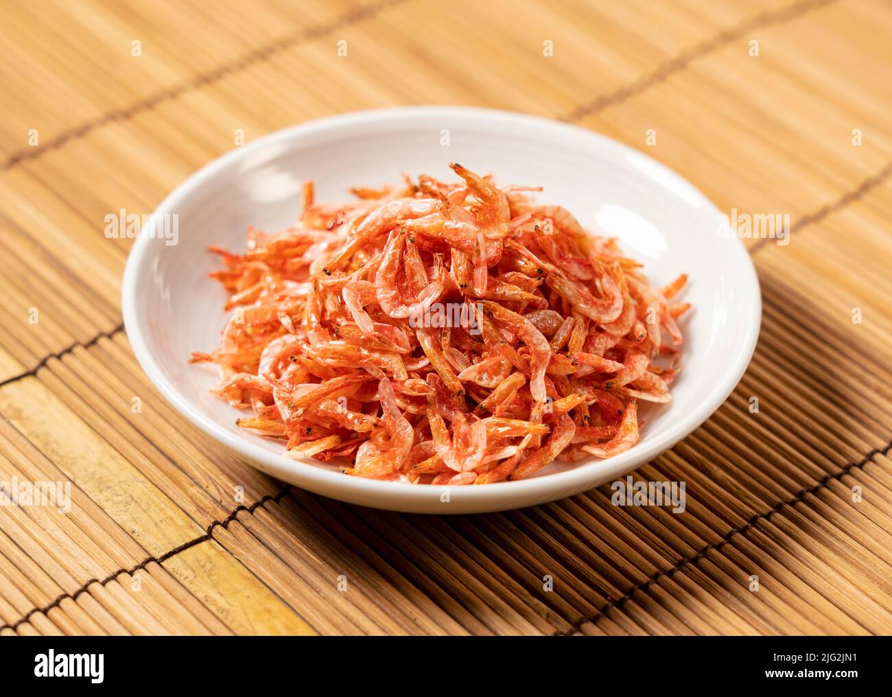 Dried sakura shrimps on a plate placed on a bamboo luncheon mat. Image ...