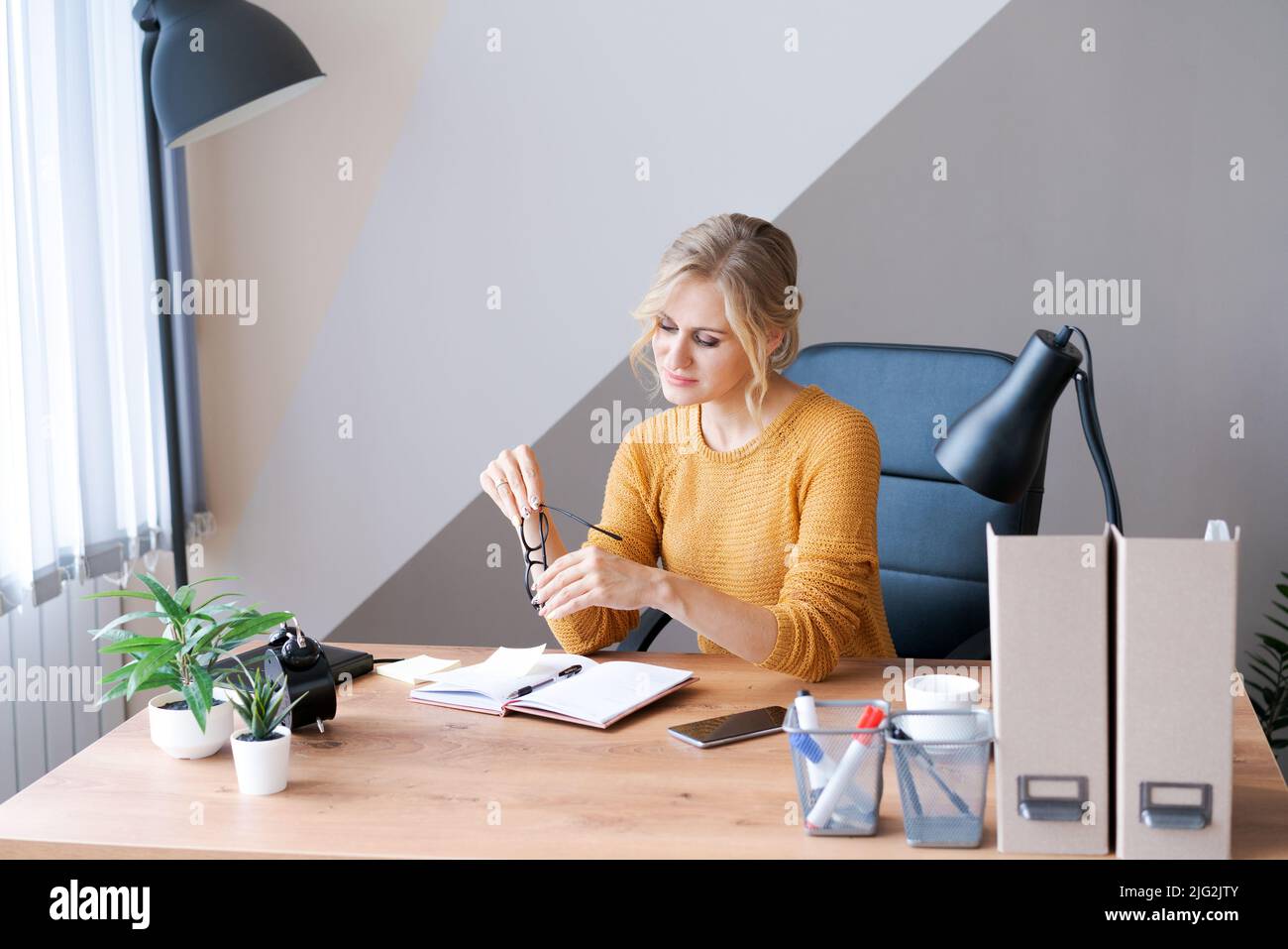 Pensive female administrative assistant. Reading information report in ...
