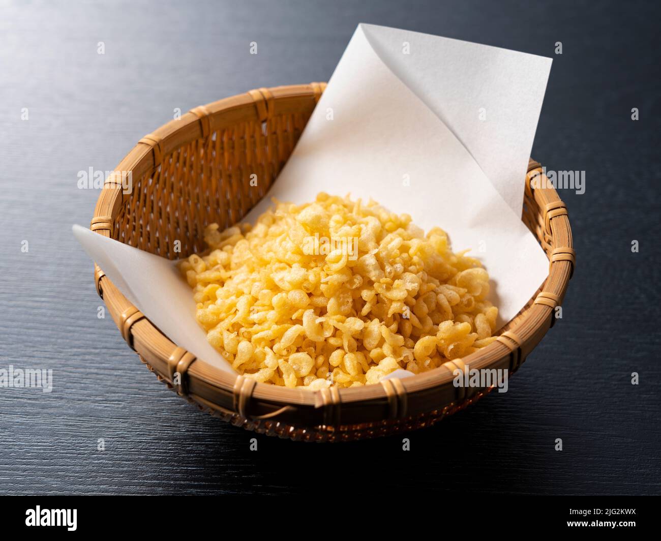 Tenkasu served in a colander placed on a black background. Image of ...