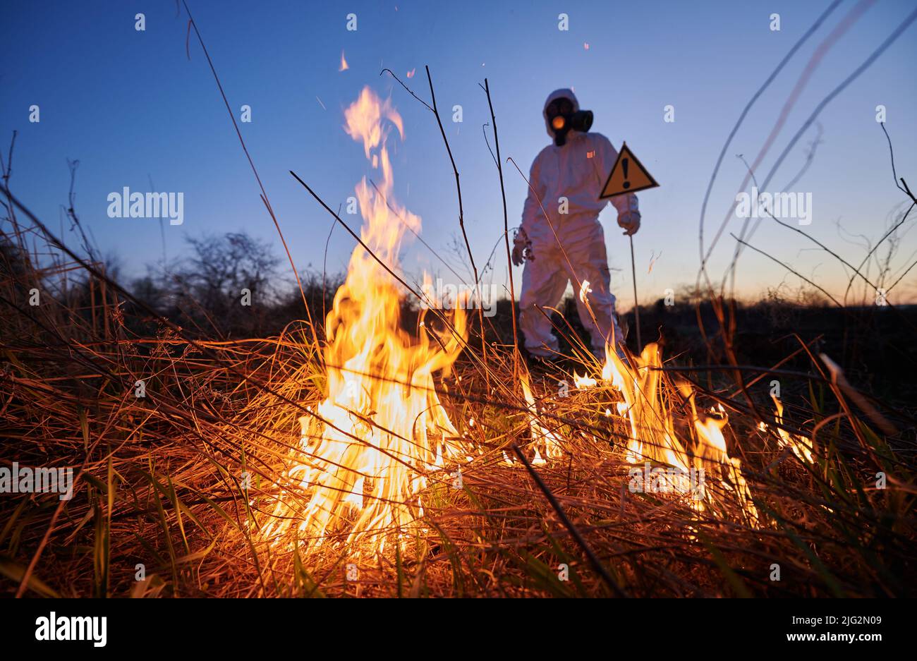Firefighter ecologist fighting fire in field at night. Man in ...