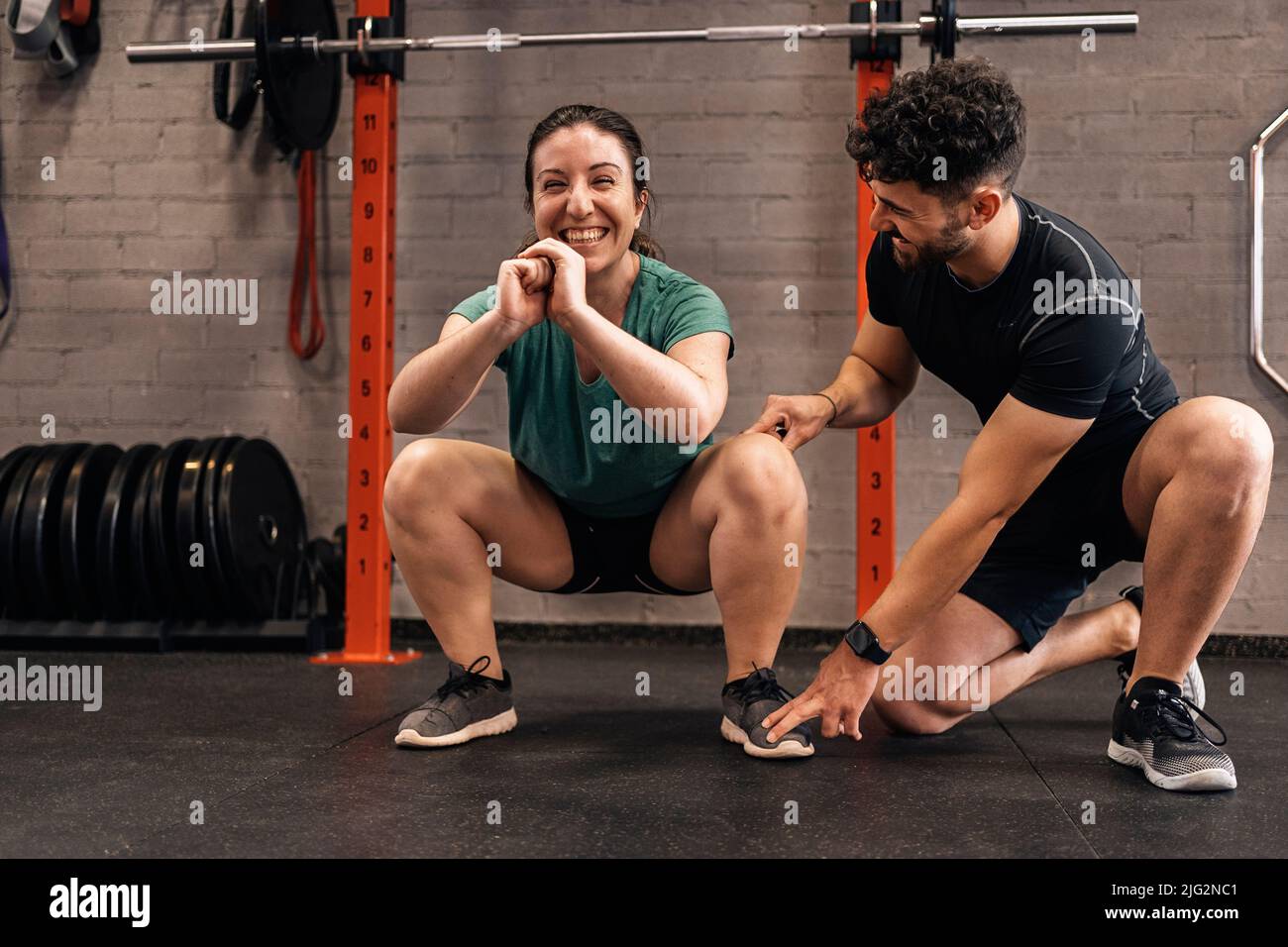 Personal trainer with a first-time trainee correcting habits in the ...