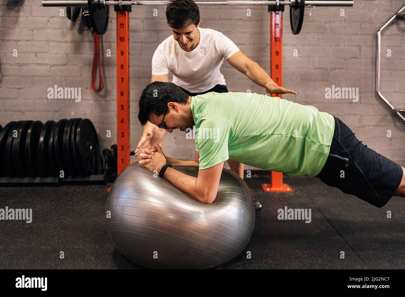 Personal trainer with a first-time trainee correcting habits in the ...