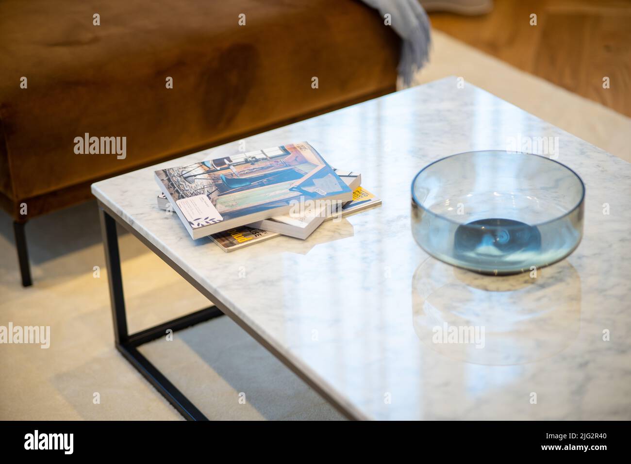 Magazine stack on a marble table next to a glass bowl Stock Photo - Alamy