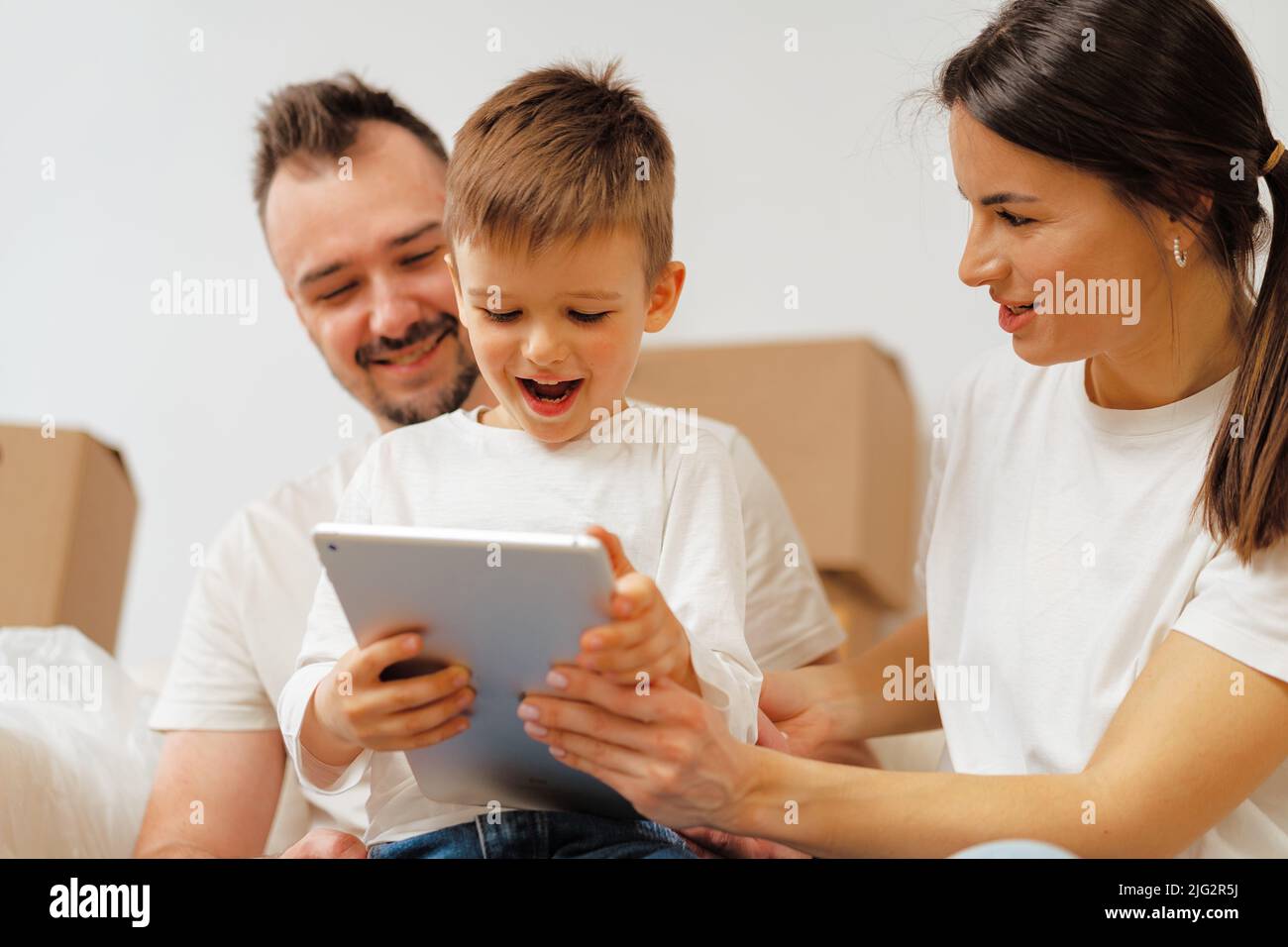Portrait of happy family with cardboard boxes in new house at moving ...