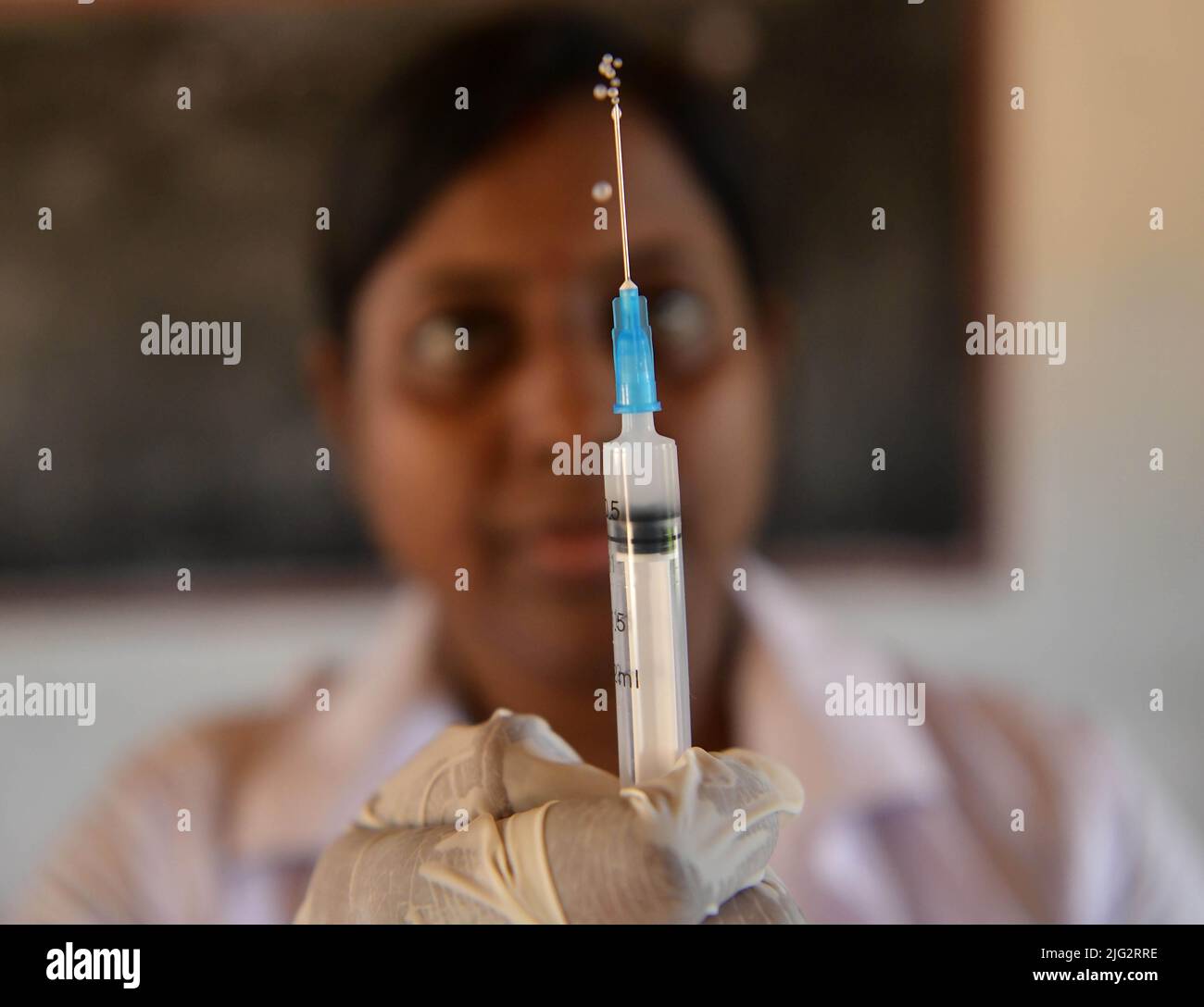 A medical worker prepares to inoculate a school student with the ...