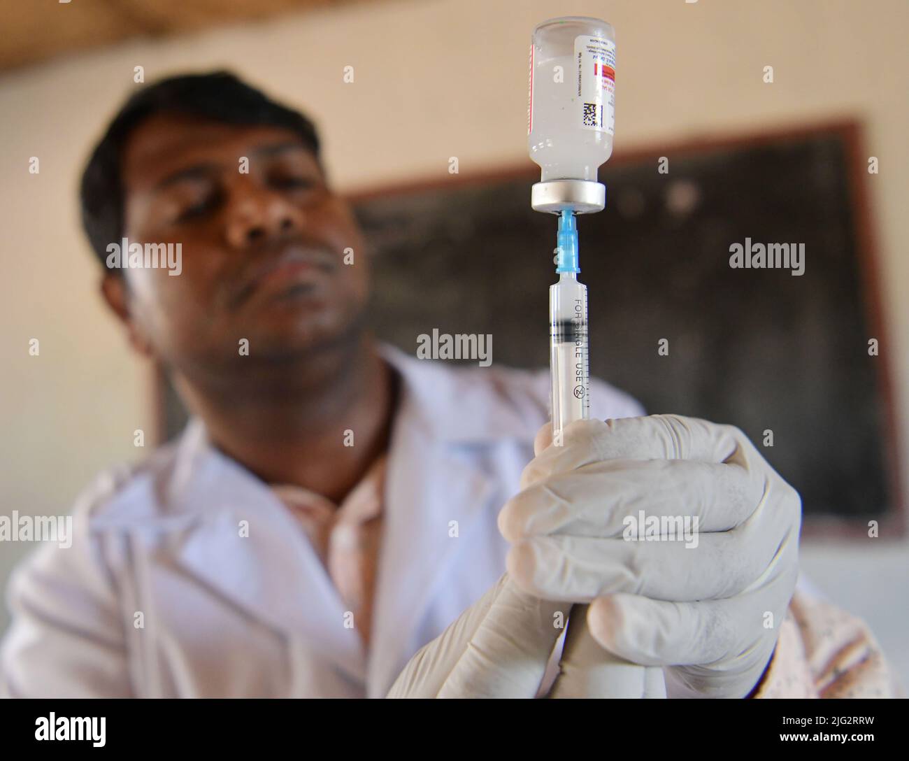 A medical worker prepares to inoculate a school student with the ...