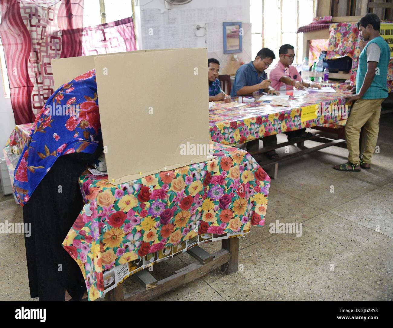 Election staff members with an electronic voting machine (EVM) during ...