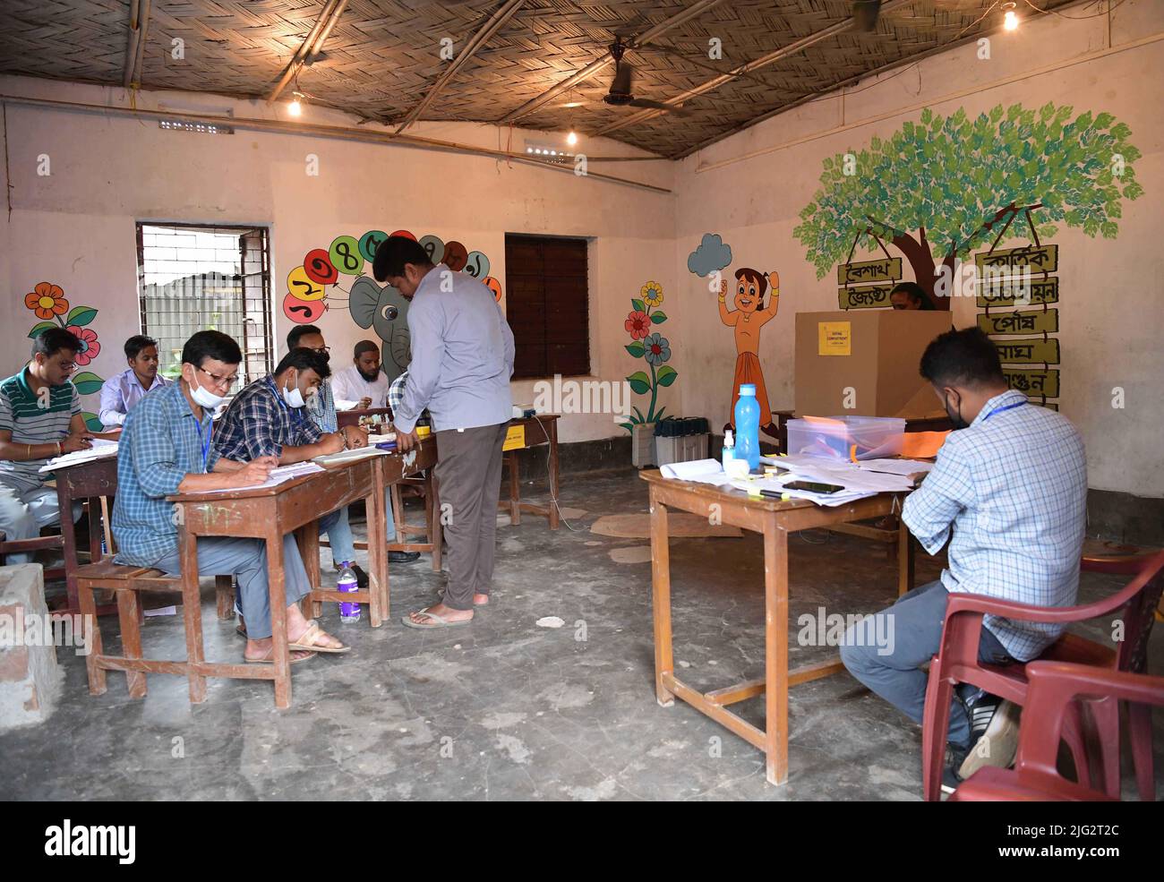 Election staff members with an electronic voting machine (EVM) during ...