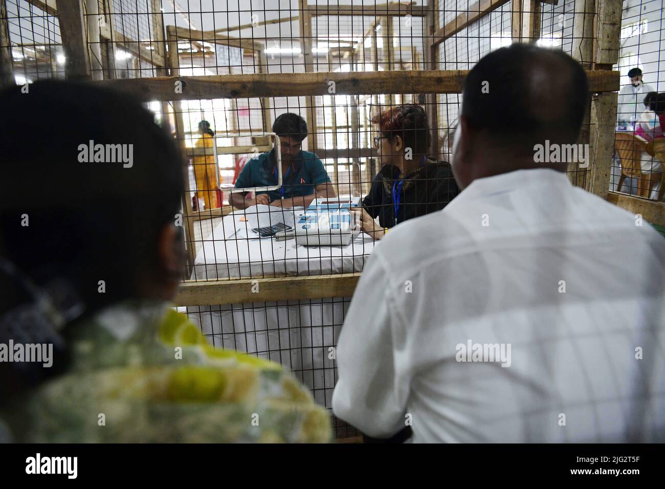Election staff members with an electronic voting machine (EVM) during ...