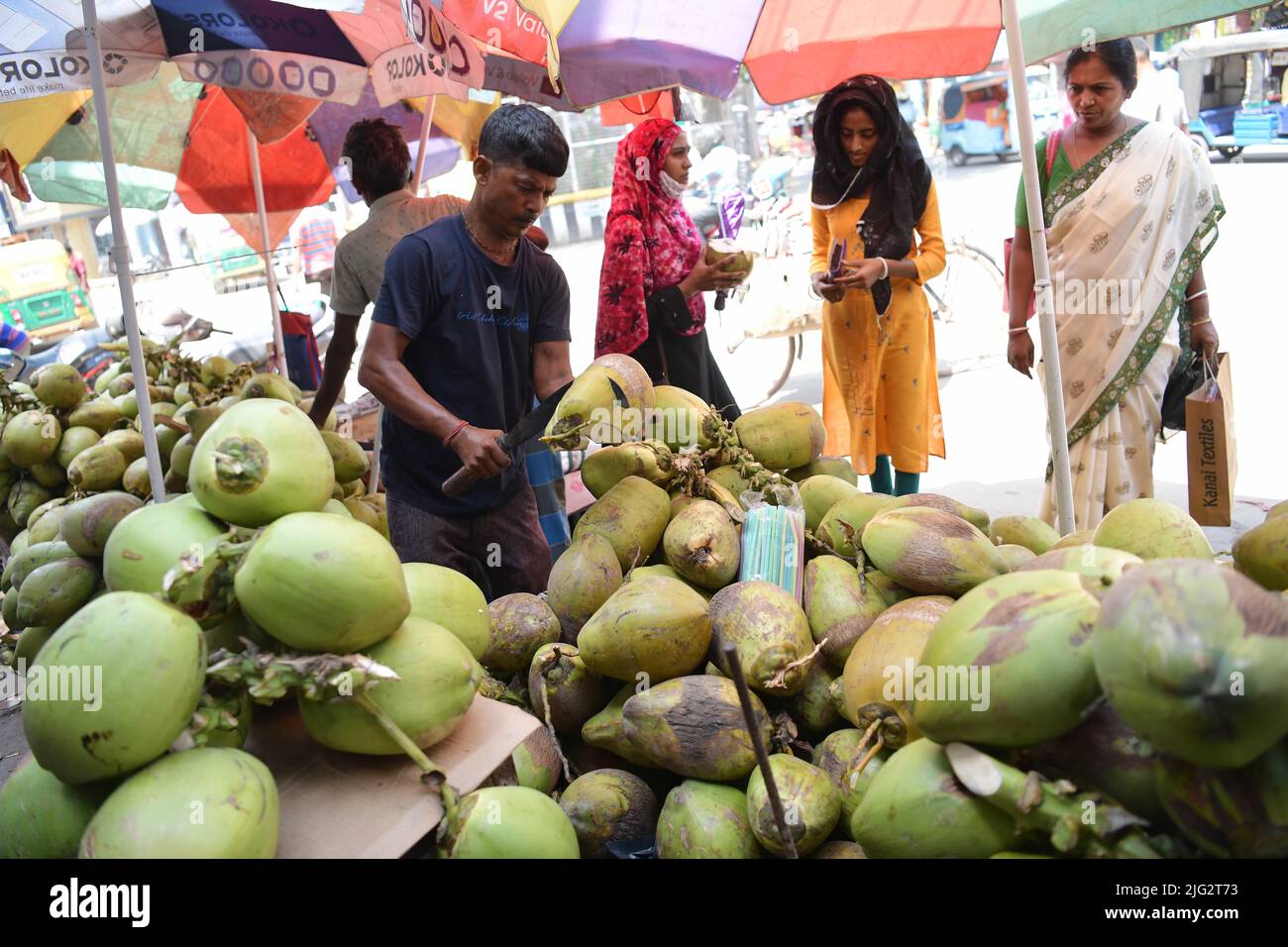 A Coconut vendor cuts coconuts and sells the coconuts to the people who ...