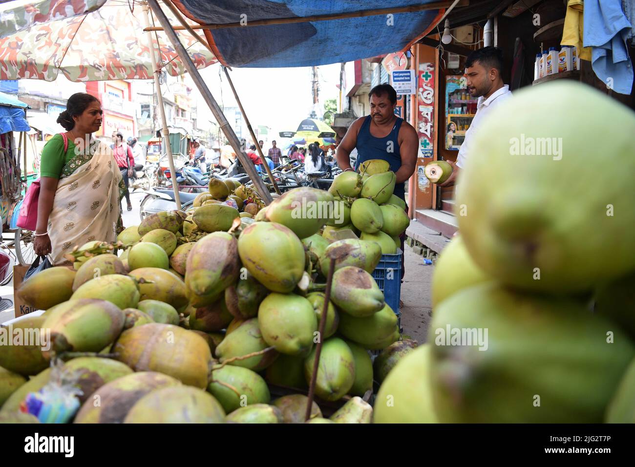 A Coconut vendor cuts coconuts and sells the coconuts to the people who ...