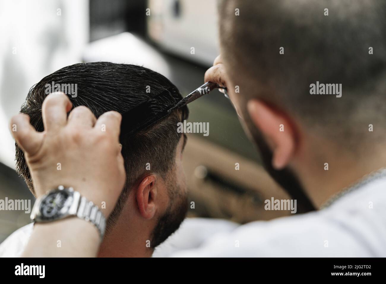 Male client getting haircut by hairdresser in barbershop Stock Photo ...