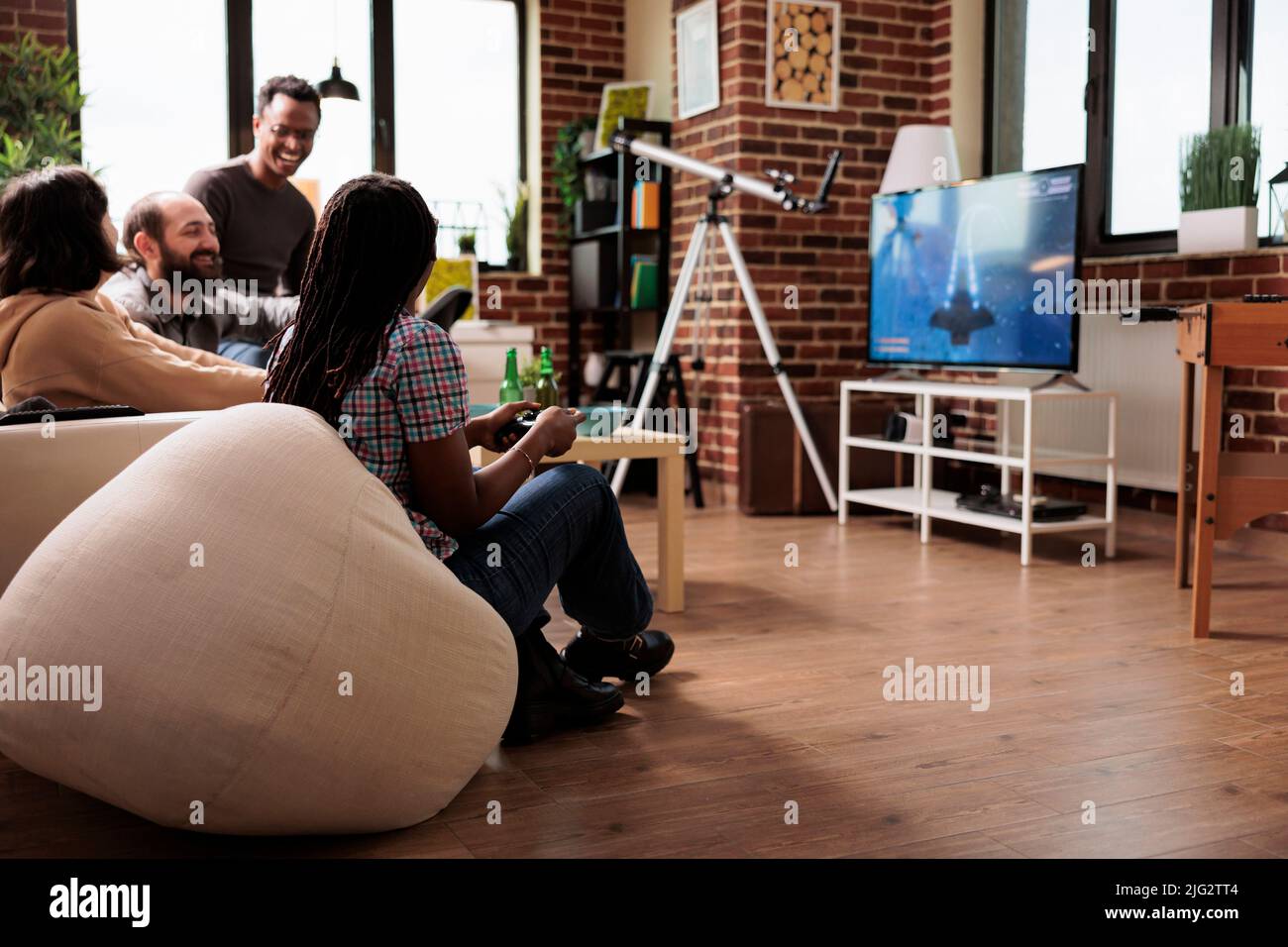 Happy smiling diverse friends sitting on sofa in living room while ...