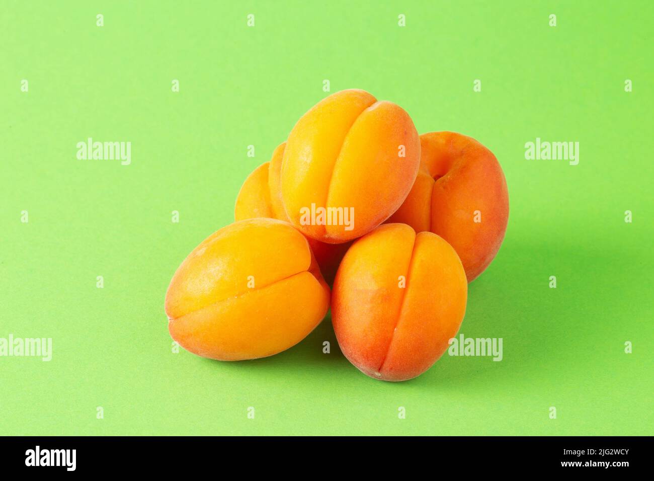 Group of fresh ripe apricots on bright green background Stock Photo - Alamy