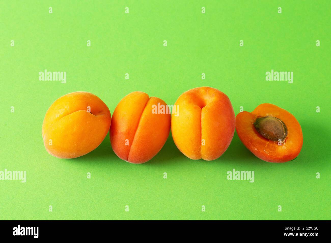 Group of fresh ripe apricots on bright green background Stock Photo - Alamy