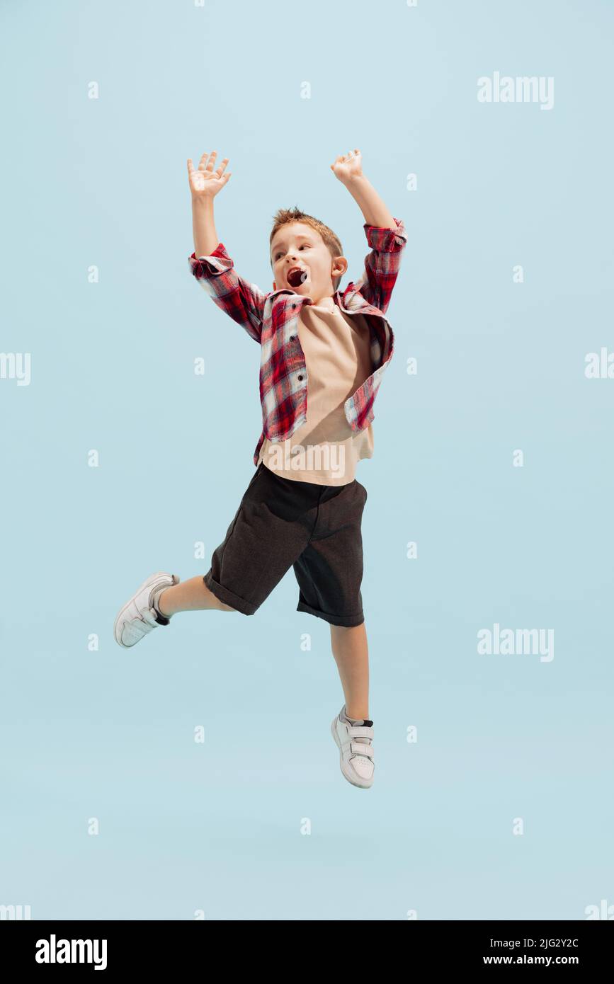 Portrait of little boy, child in checkered shirt cheerfully jumping ...