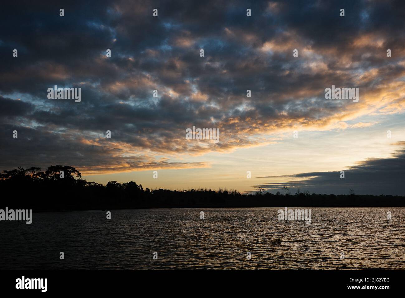 Dramatic sunrise sky covered by clouds make darkness to the dam and ...
