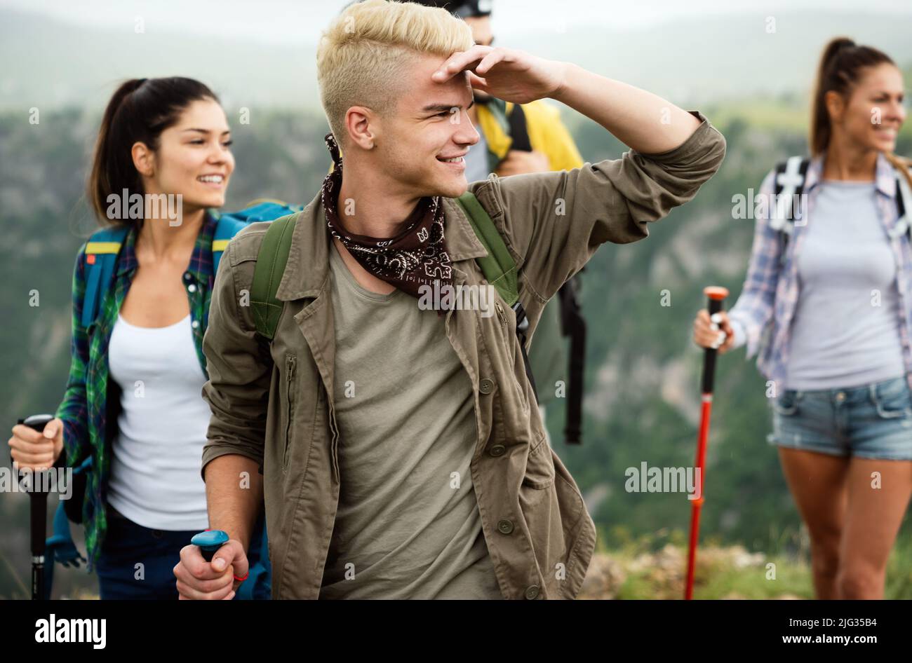 Group of friends hiking together outdoors exploring the wilderness and ...