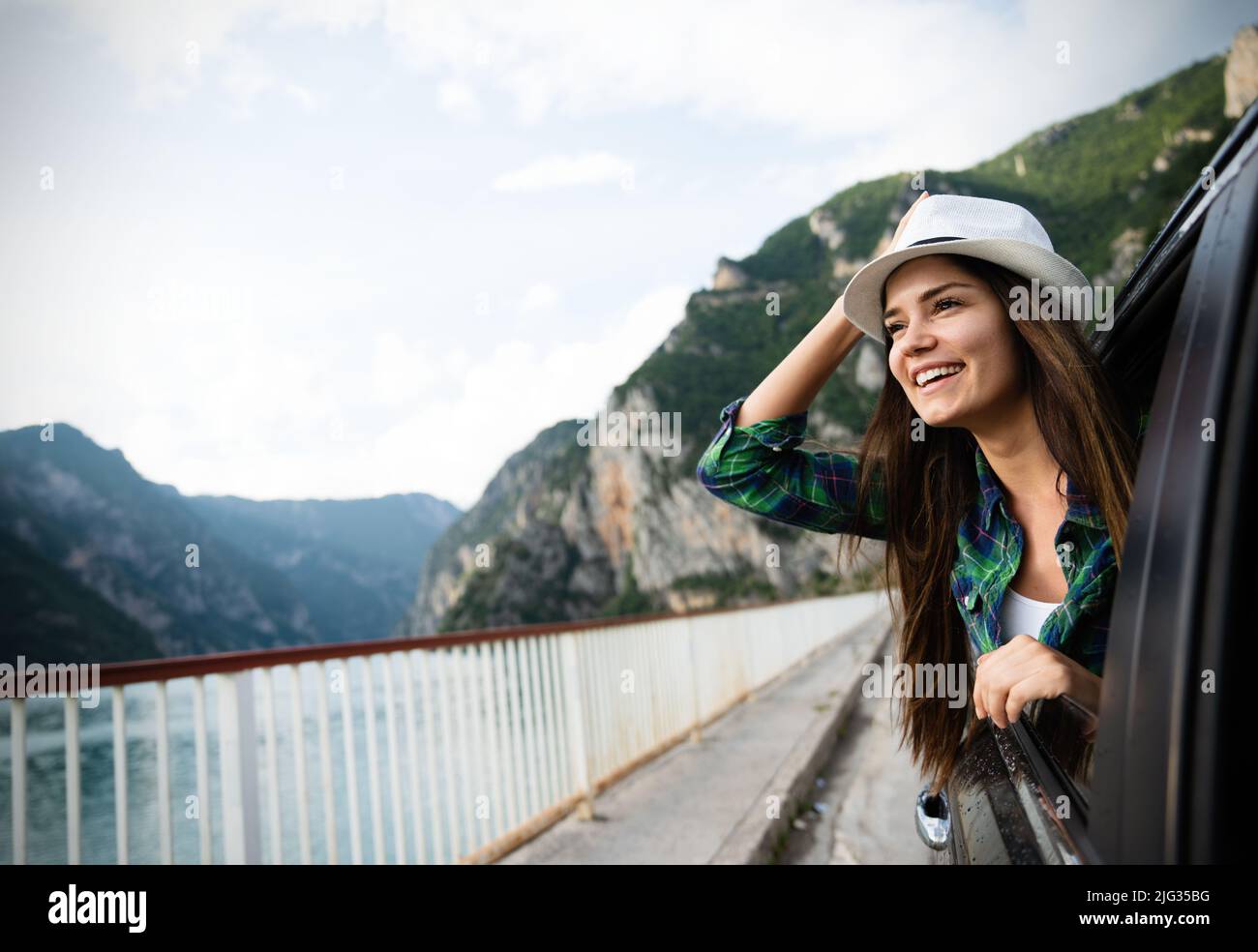 Woman in car road trip waving out the window smiling Stock Photo - Alamy
