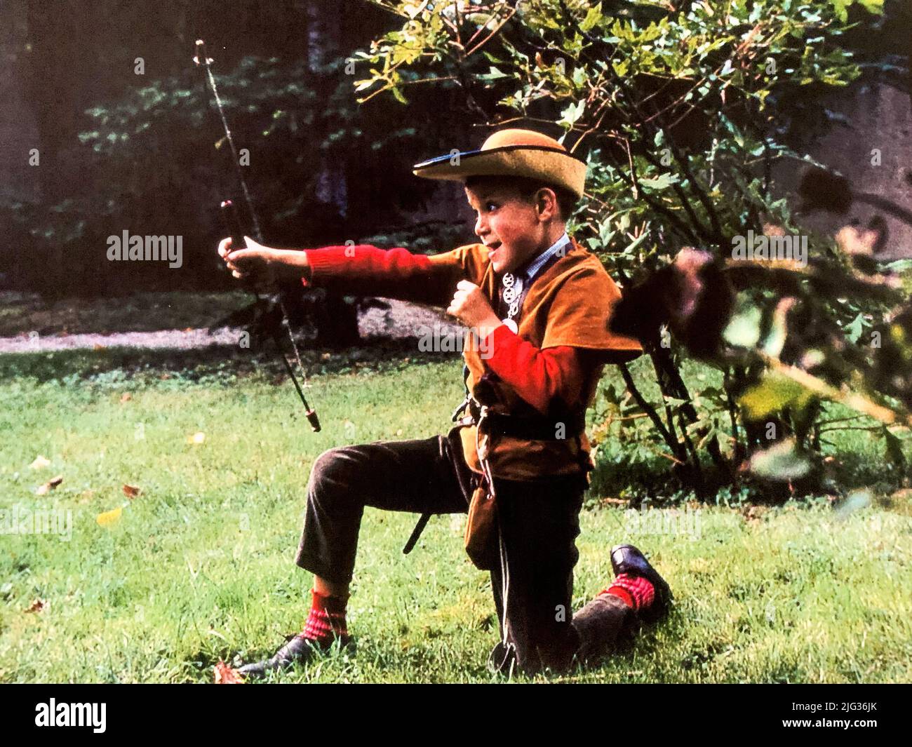 A young boys wearin a disguisement of Thierry la Fronde plays in garden ...