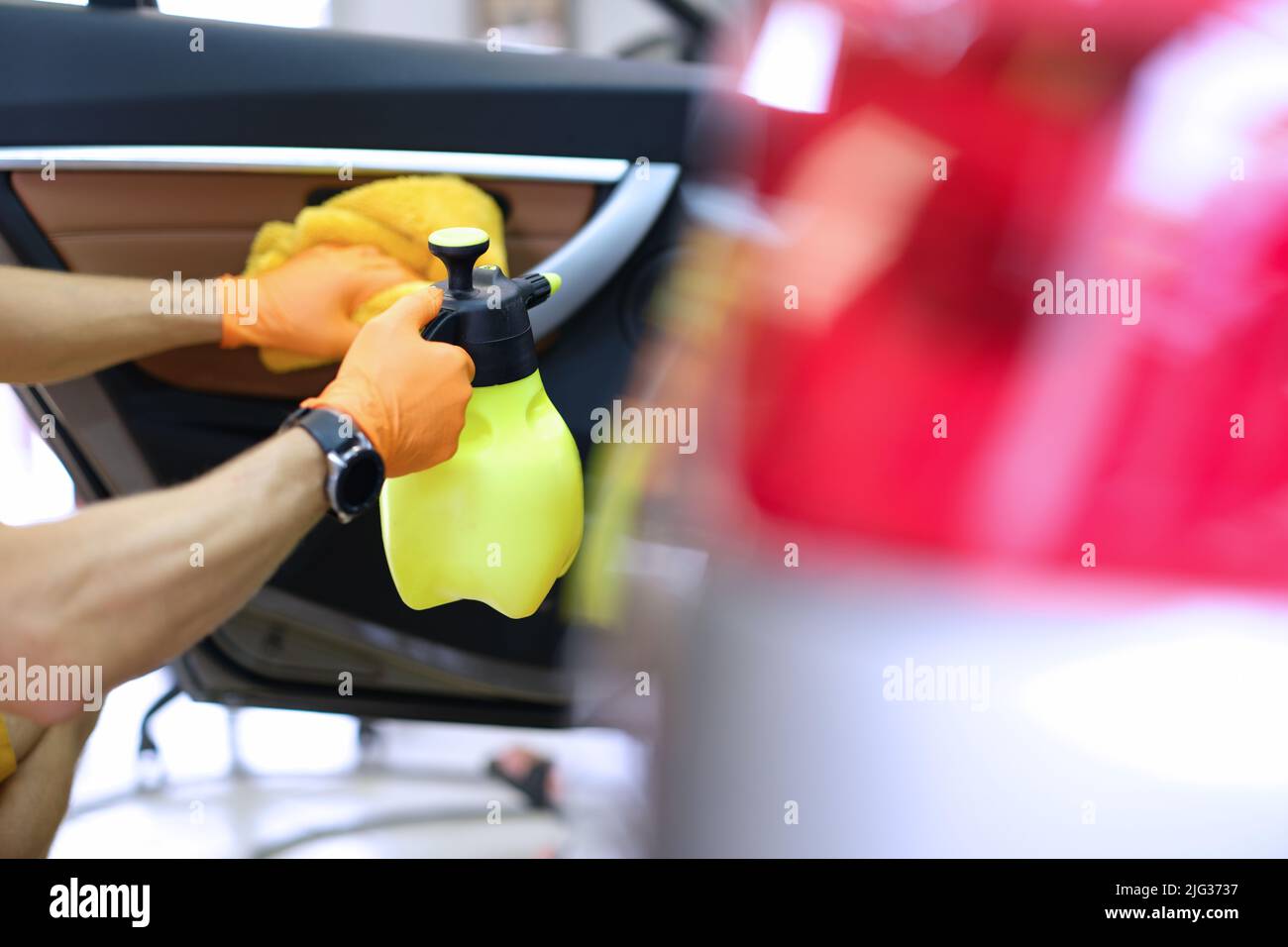 Cropped view of car washer holding rag and aerosol can washing car door ...