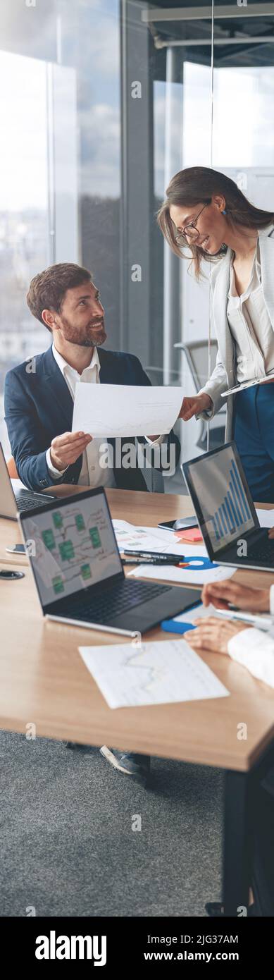 Beautiful business people are using gadgets, talking and smiling during ...