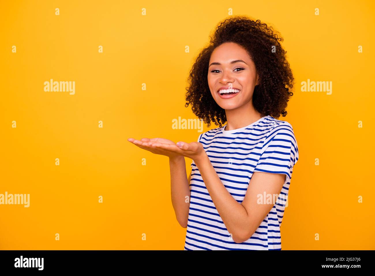 Photo of pretty sweet girl dressed striped t-shirt holding arms empty ...
