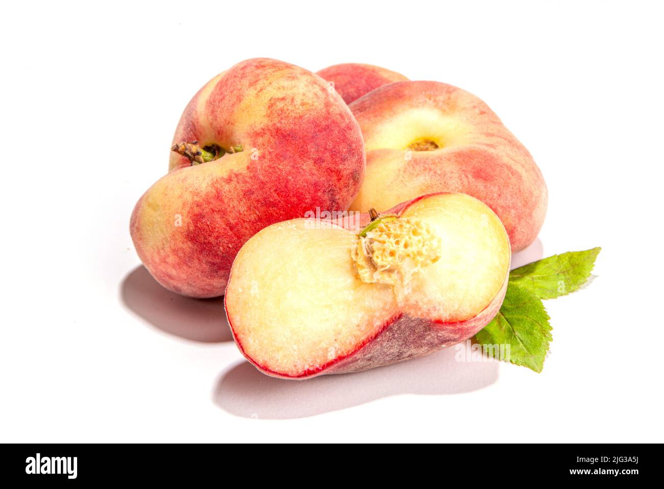 Ripe organic chinese flat fig peach, whole and slices, with leaves ...