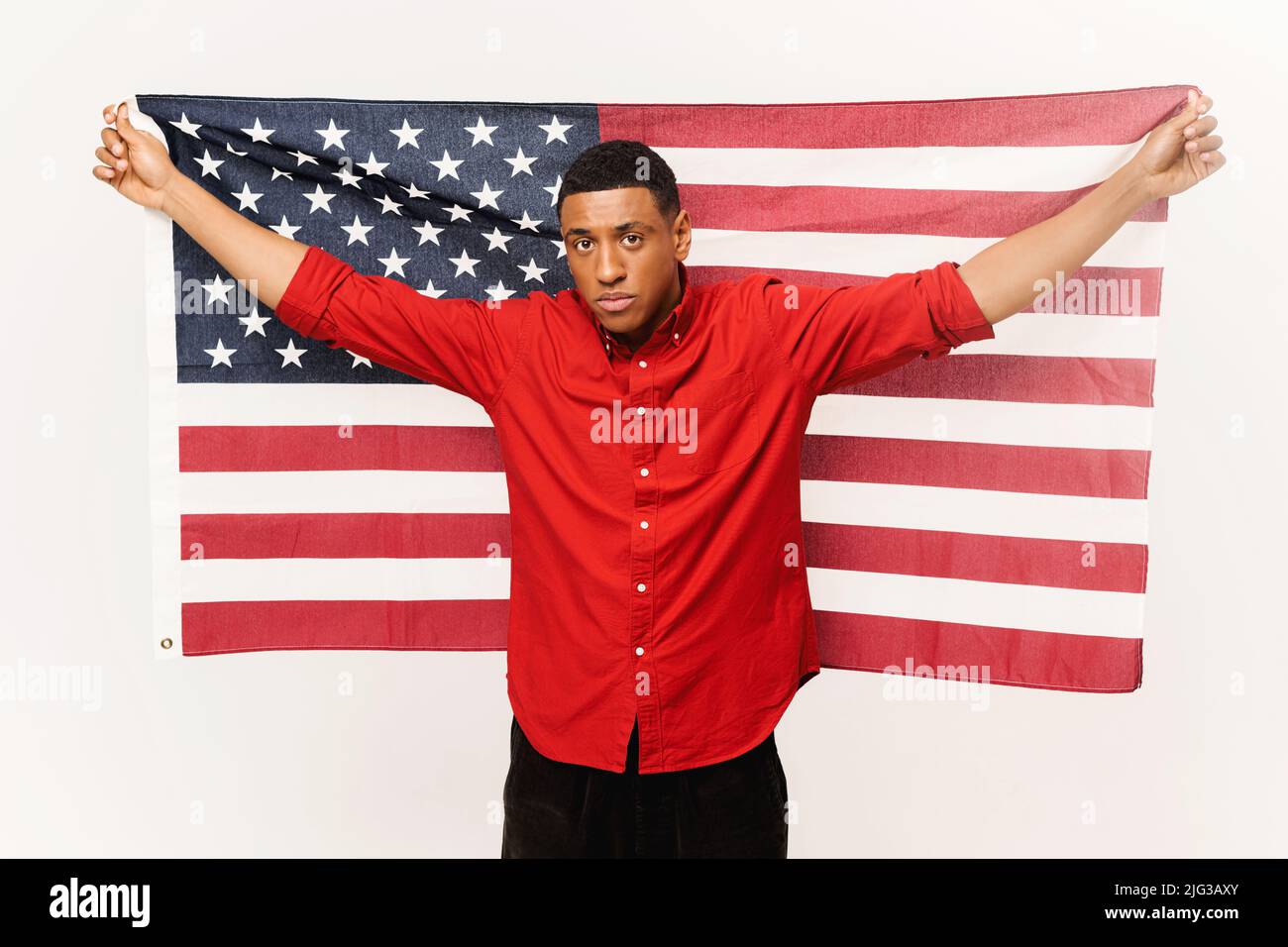 Serious African-American guy holding in hands american flag isolated ...