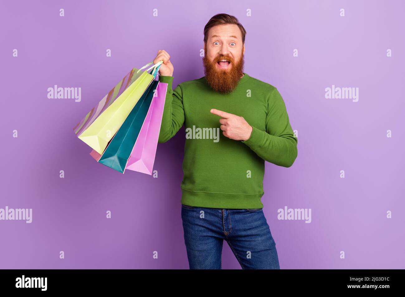 Photo of excited attractive male show you his shopping bags visit mall ...