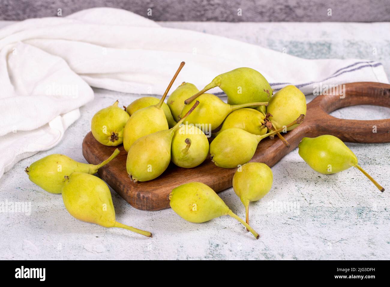 Fresh pear. Ripe pears in a wooden serving dish on a stone background ...