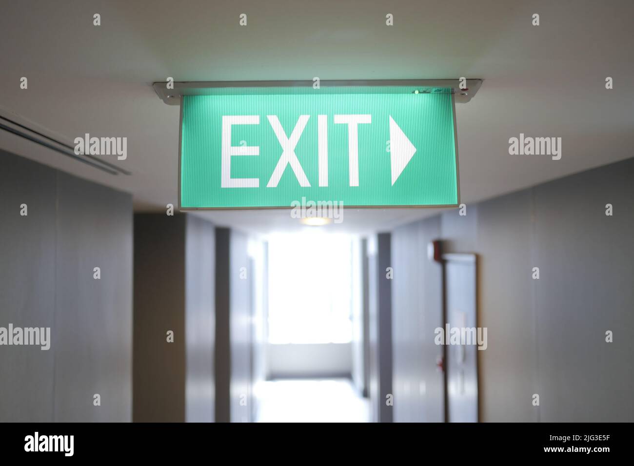 Fire exit sign in the middle of the the corridor in building Stock ...