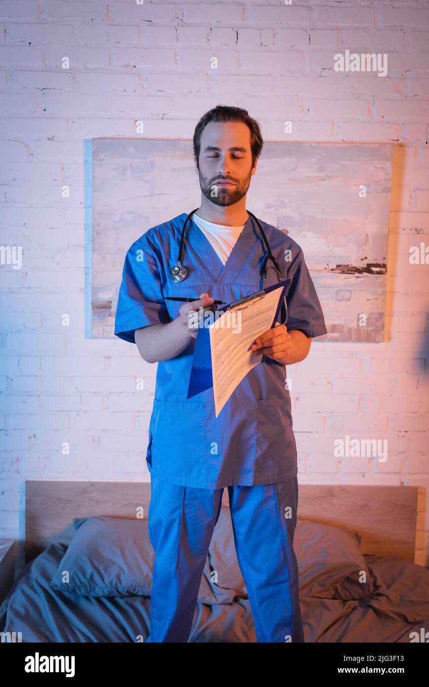 Somnambulist in doctor uniform holding pen and clipboard on bed at ...