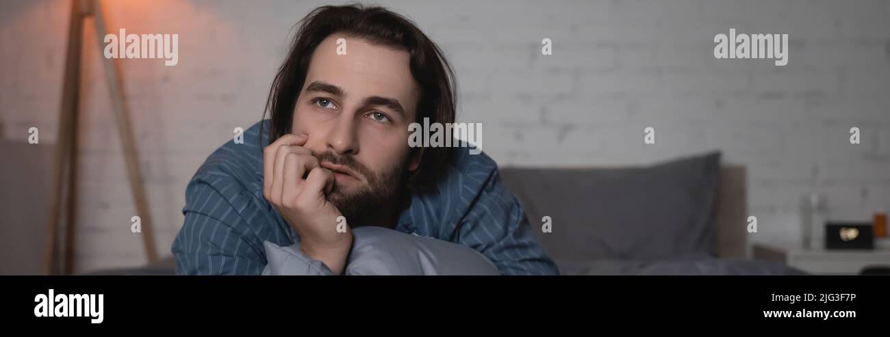Sleepless man in pajama lying on bed at night, banner Stock Photo - Alamy
