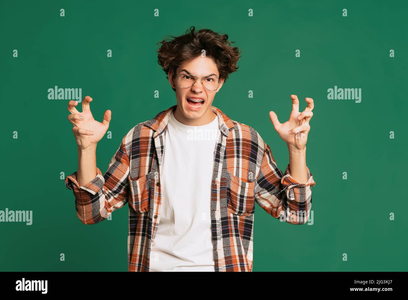 Angry young boy, teen in casual style clothes posing isolated over ...