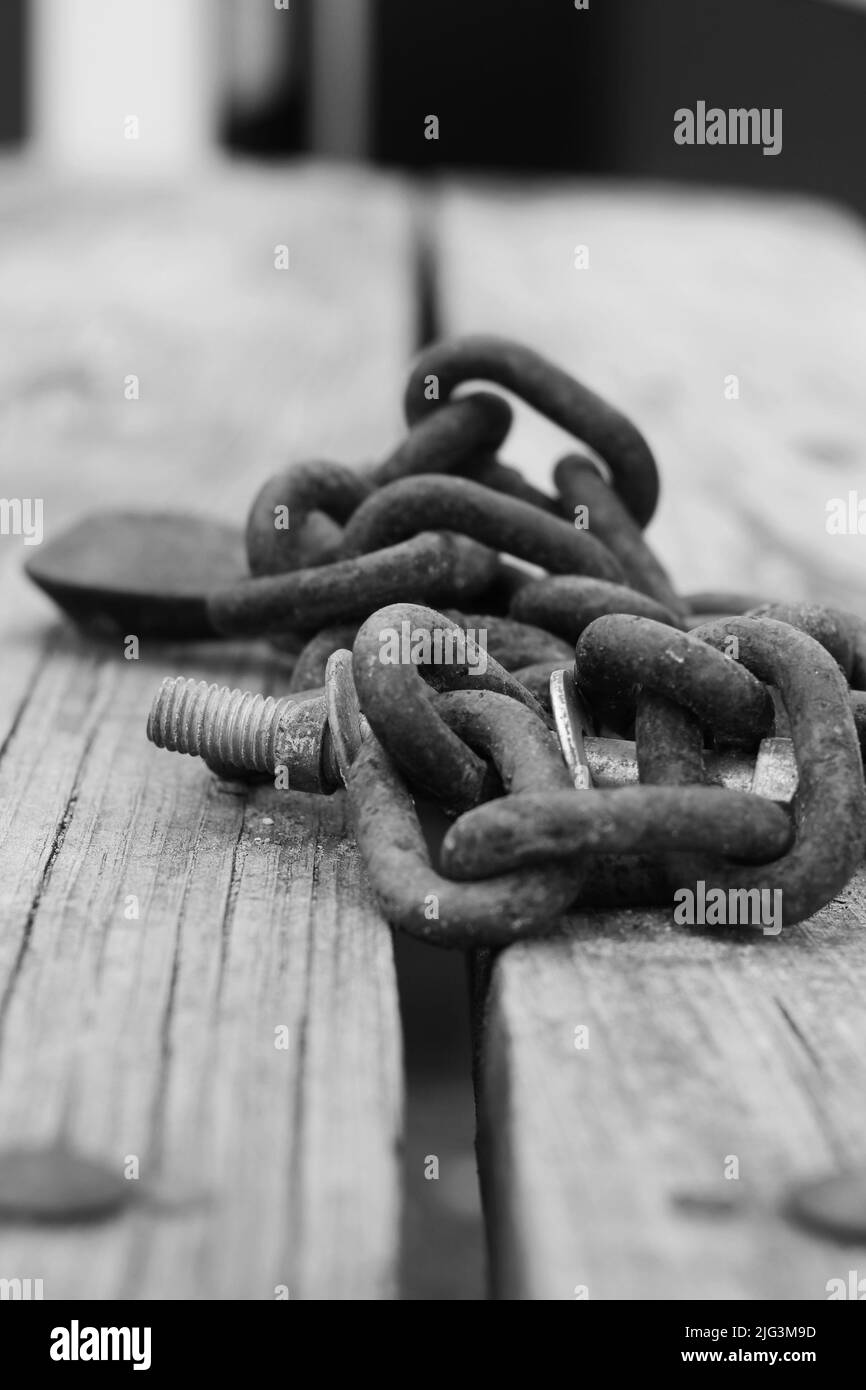 Heavy duty industrial strength chain laying on a wooden table top in ...