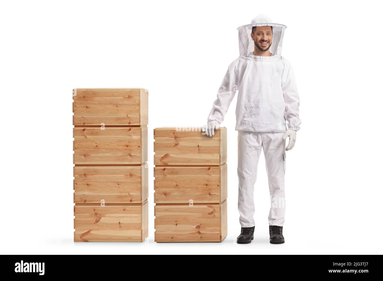 Bee keeper in a uniform standing next to wooden crate piles isolated on ...