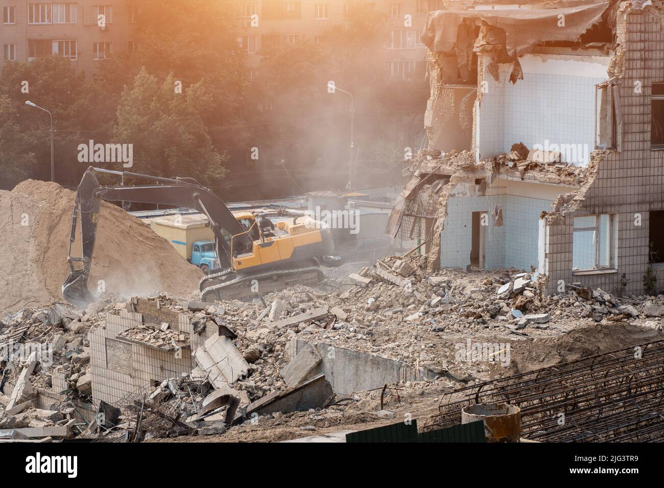 demolition old building by excavator near new construction of modern ...