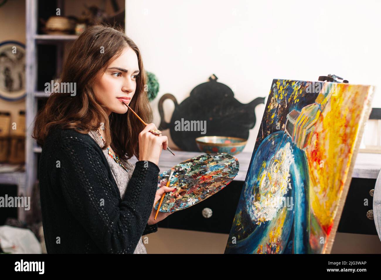Creative pensive painter paints a colorful picture Stock Photo - Alamy