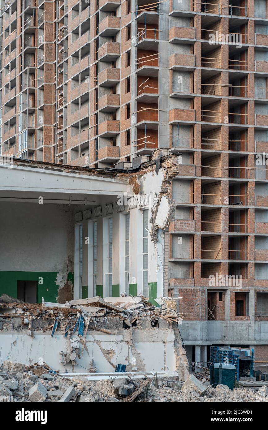 demolition of old building near new construction of modern skyscraper ...