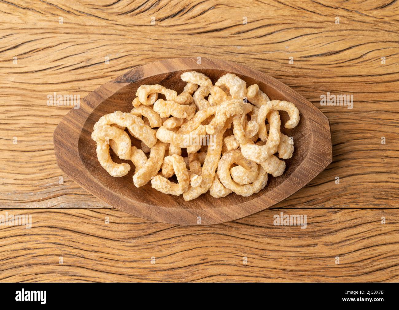 Fried pork skin cracklings on a plate over wooden table Stock Photo - Alamy