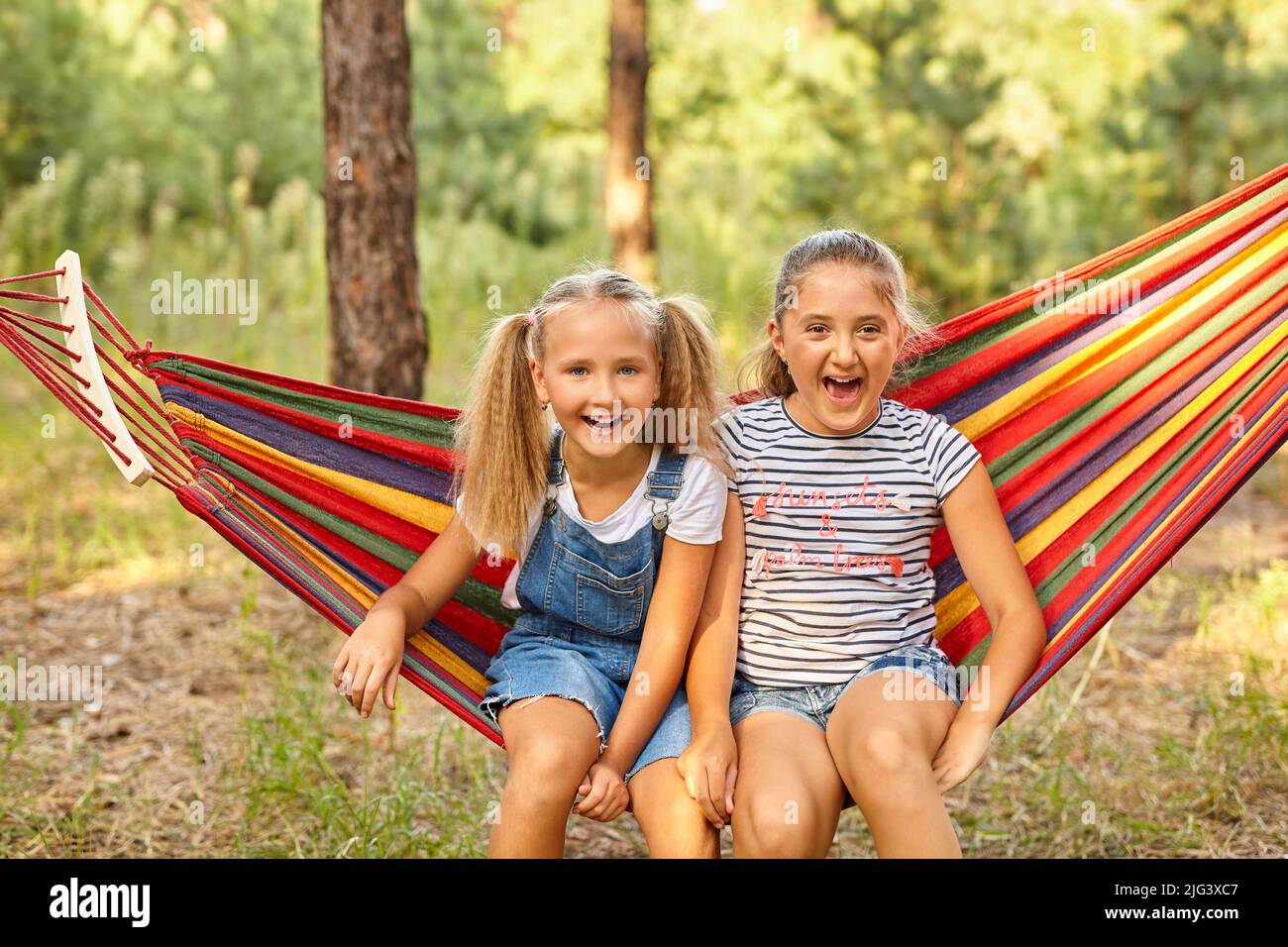 Kids relax in colorful rainbow hammock. cation. Children relaxing Stock ...