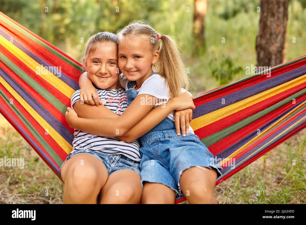 Kids relax in colorful rainbow hammock. cation. Children relaxing Stock ...