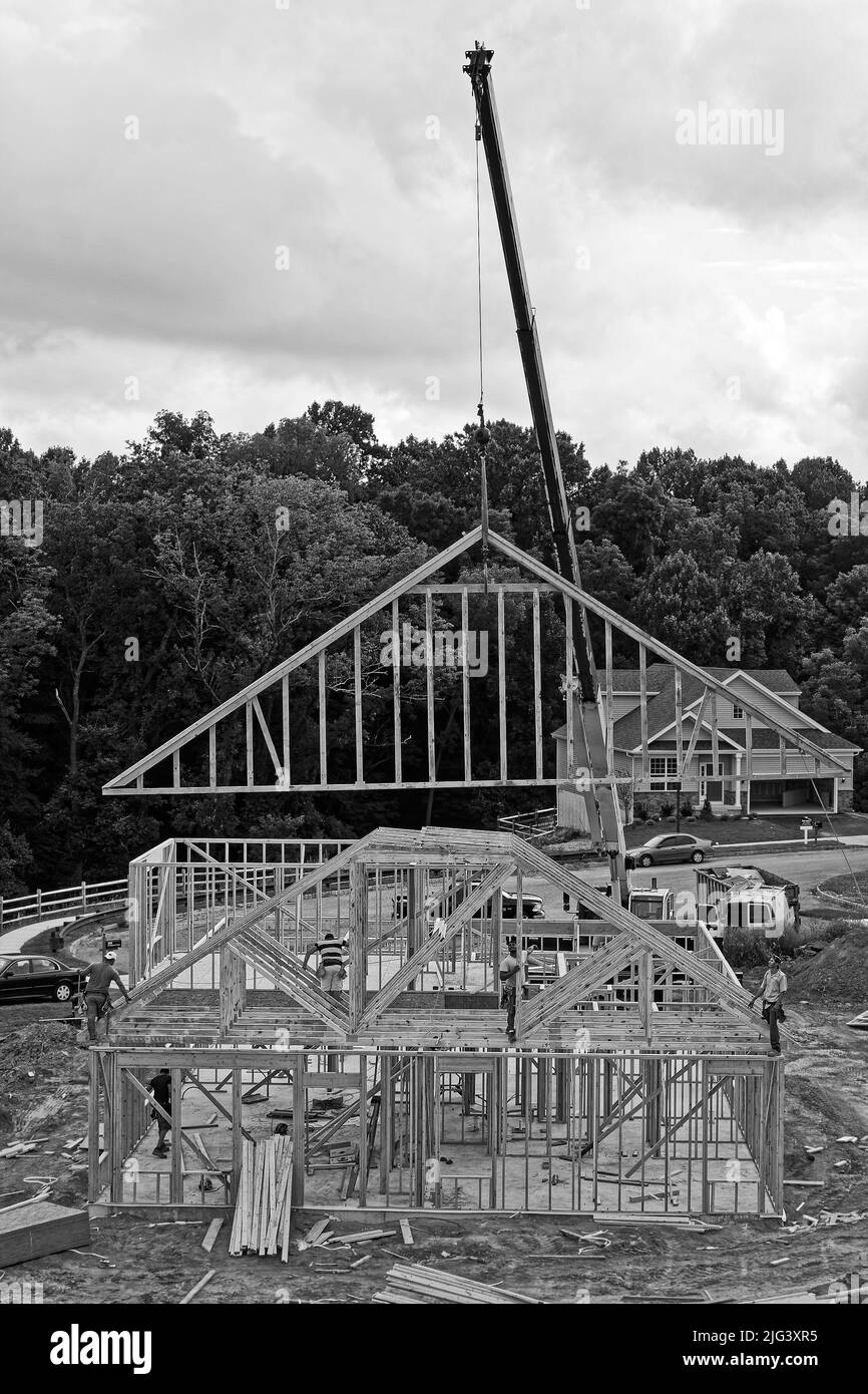 new house construction, framed, men working, crane putting piece into ...