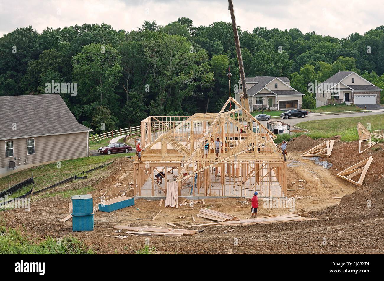 new house construction, framed, men working, crane putting piece into ...
